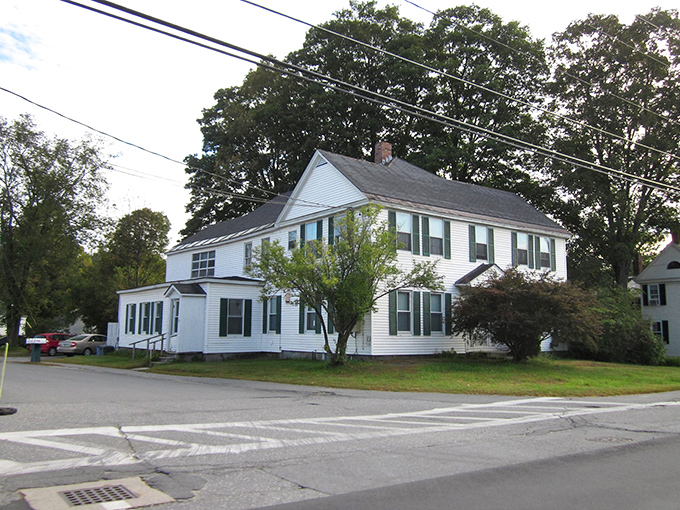 Strolling through Chester, Vermont, this vintage white house stands gracefully, framed by trees and timeless charm.