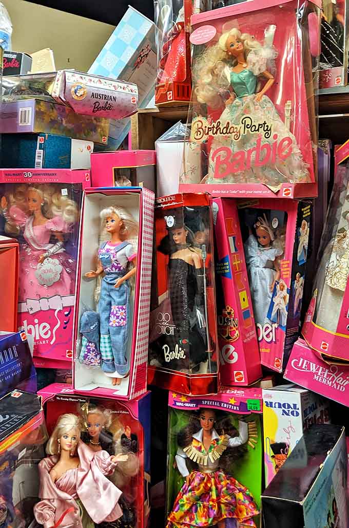 Boxed Barbie dolls from across the decades create a timeline of fashion and cultural shifts, preserved in their original packaging like time capsules.