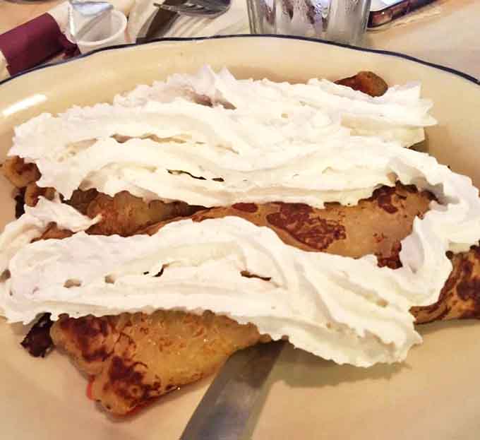 Strawberry crepes that straddle the line between breakfast and dessert, with whipped cream so abundant it deserves its own zip code.