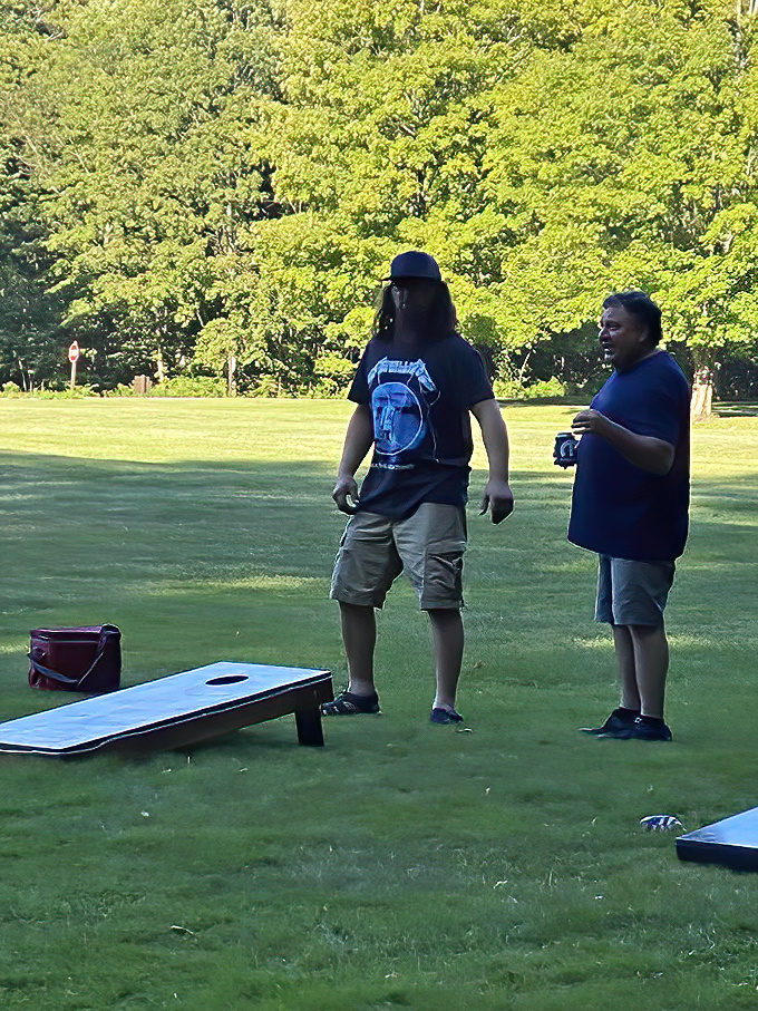 Friendly competition unfolds on the lawn &ndash; cornhole boards waiting for that perfect toss as afternoon shadows lengthen.