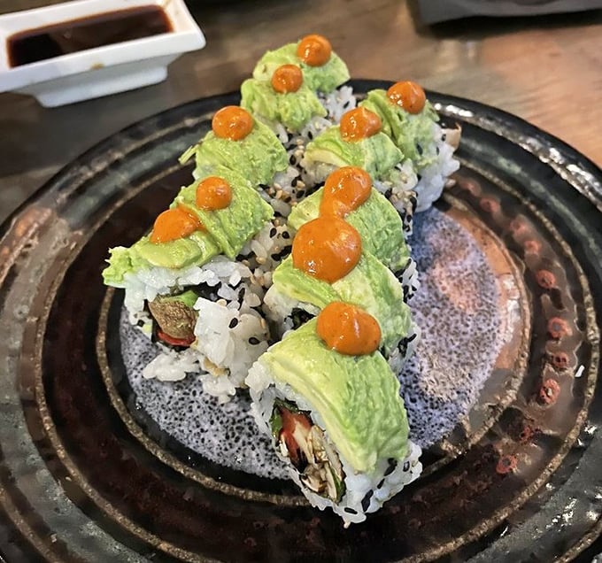 Vibrant green avocado crowns these rolls like edible jewelry, each topped with a pop of orange roe.