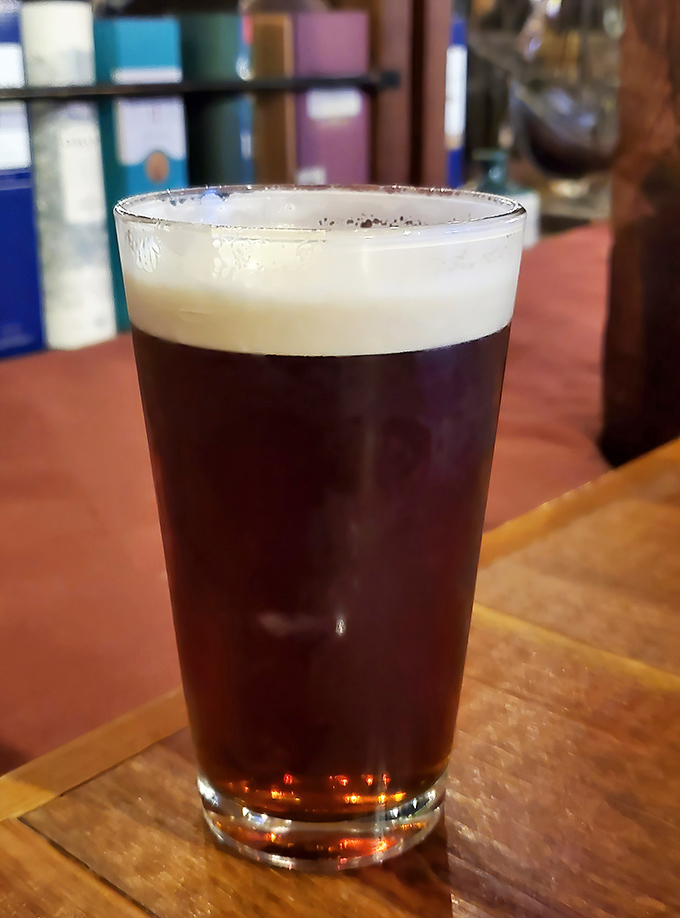 A perfectly poured pint of dark ale shows off the pub's commitment to quality beverages that complement their exceptional food offerings.