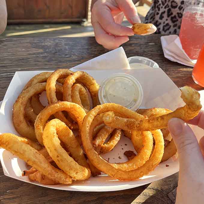 Crispy onion rings that achieve that perfect balance between substantial and delicate, ideal for sharing or hoarding.