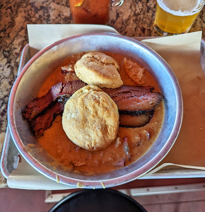A hearty bowl featuring tender brisket swimming in savory broth, with cornbread islands ready for exploration.