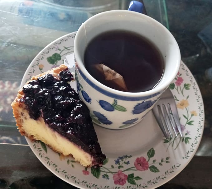 The perfect Maine afternoon: a slice of wild blueberry cheesecake paired with a steaming cup of locally blended tea.