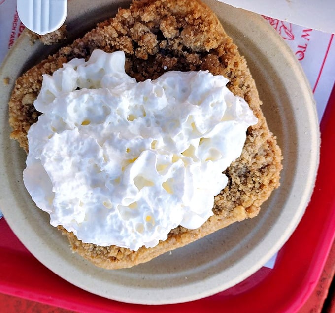 A slice of Maine blueberry pie topped with whipped cream, the ideal sweet finale to a seaside feast.