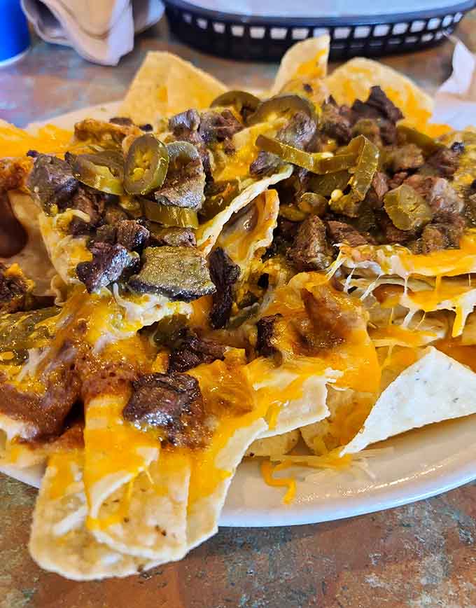 Muchos Nachos lives up to its name with a mountain of chips, cheese, and toppings.