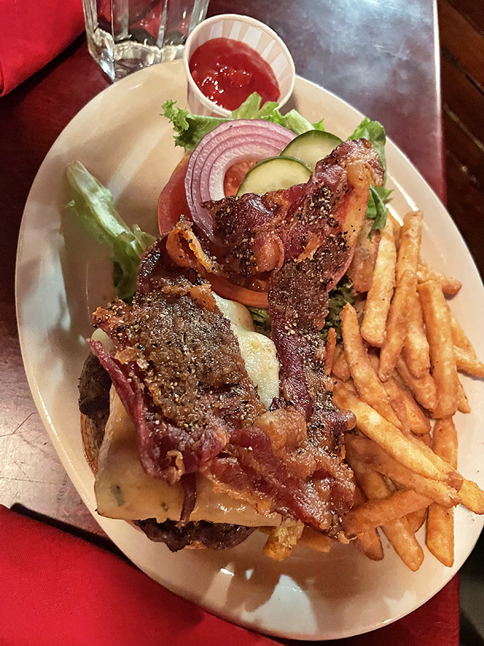 Burger bliss achieved: melty cheese cascading over a juicy patty, crowned with bacon that shatters with each heavenly bite.