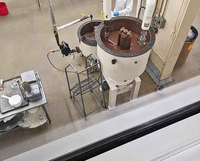 Behind the scenes magic &ndash; molten chocolate swirls hypnotically in industrial mixers where confectionery dreams begin their journey to delicious reality.