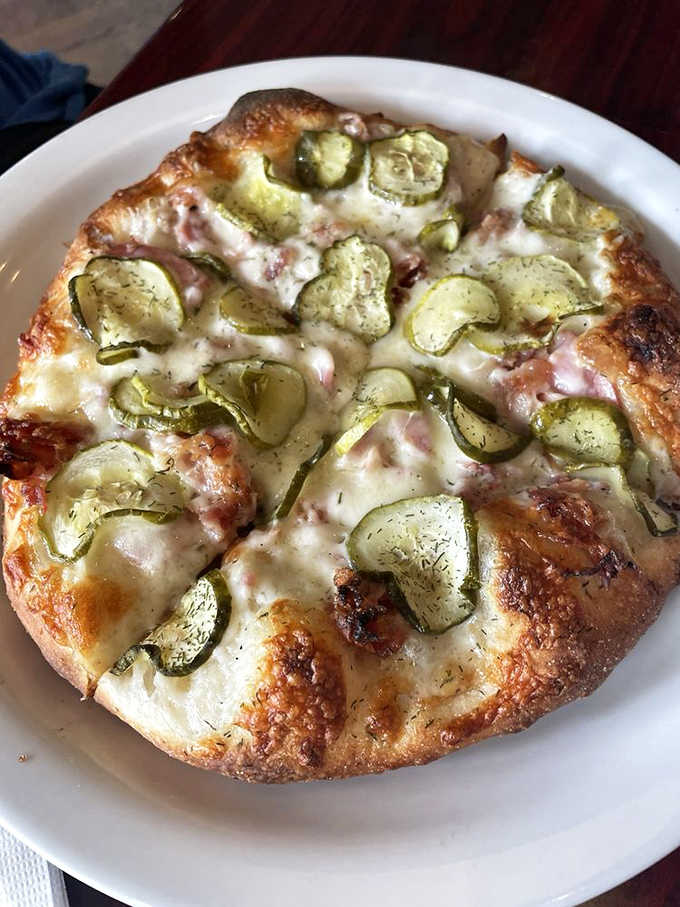 The famous pickle pizza that converts skeptics into evangelists with its perfect harmony of garlic sauce, mozzarella, and dill pickle slices.