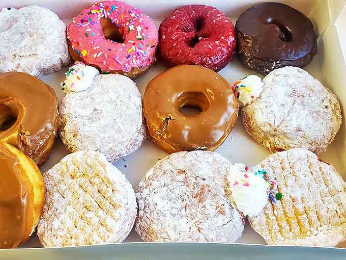 Donut heaven exists, and it looks exactly like this box. From sprinkles to glazes, each one promises a different path to sugar-induced bliss.
