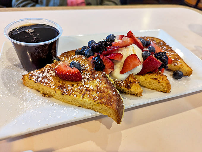 French toast done right, thick-cut and golden, topped with fresh berries and whipped cream that turns breakfast into a celebration.