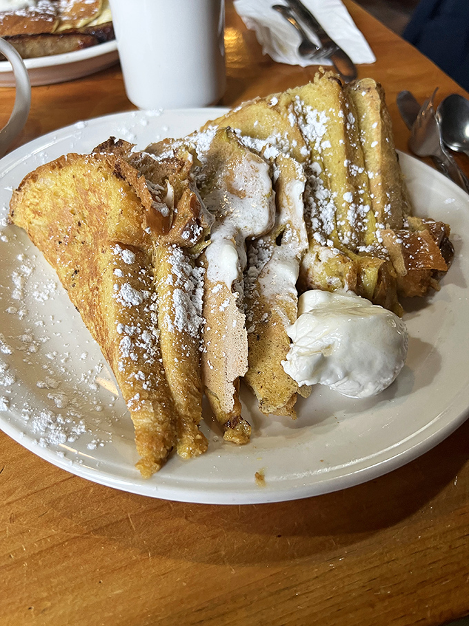 French toast dusted with powdered sugar stands tall and proud, ready to make your breakfast dreams come true.