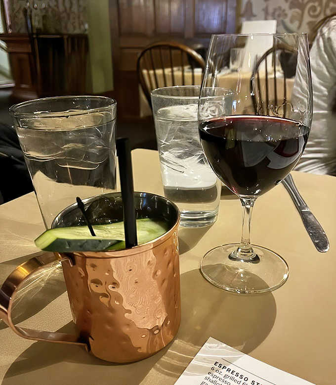 A copper mule mug stands guard beside ruby wine &ndash; liquid companions that transform a meal into a celebration.