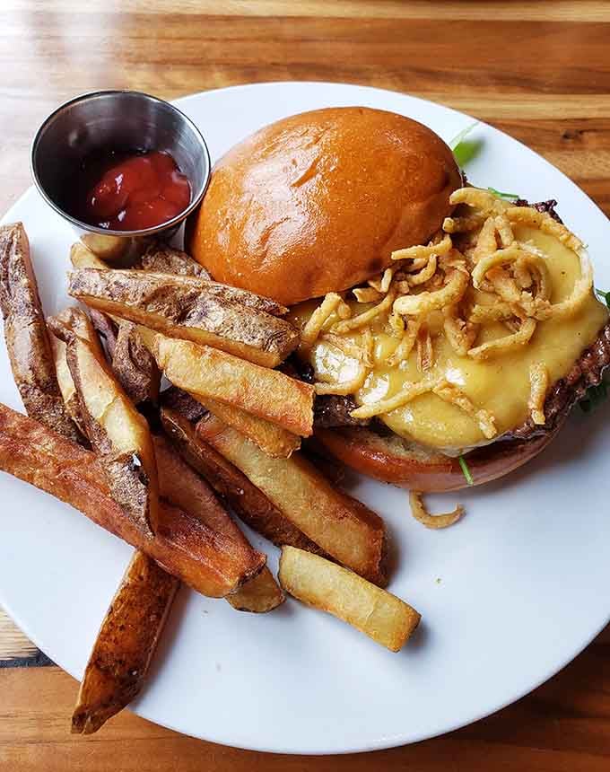 The George Burger comes loaded with enough toppings to require structural engineering, served with crispy fries for good measure.
