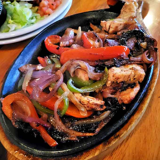 Sizzling fajitas announce their arrival with theatrical flair, a sensory experience of sight, sound, and mouthwatering aromas.