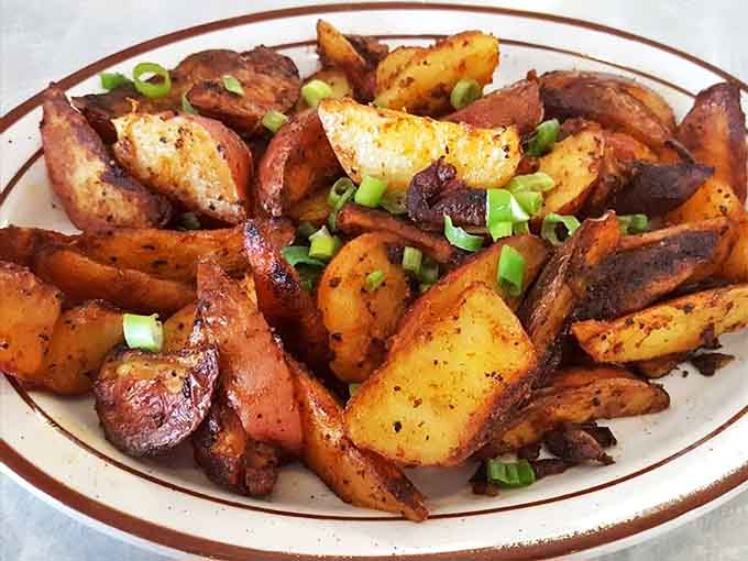 Home Fries: Golden-brown potato perfection sprinkled with green onions &ndash; these aren't mere side dishes, they're crispy supporting characters deserving applause.