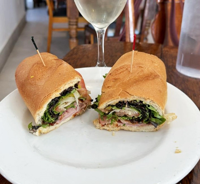 A hearty Italian sandwich reveals layers of meats and greens, delivering simple satisfaction in every bite.