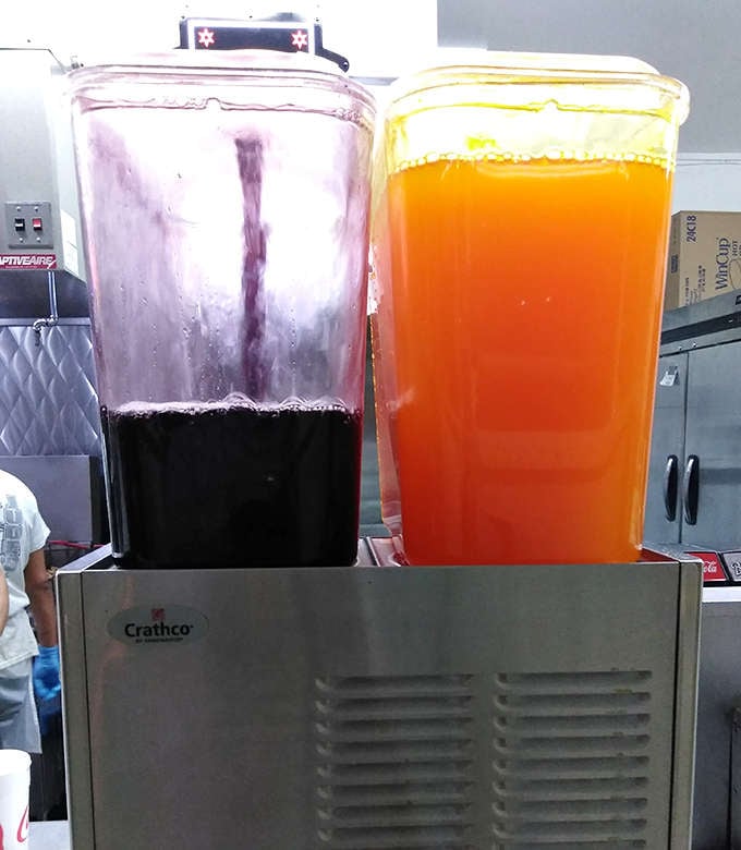 Vibrant dispensers of orange and grape drinks stand ready to deliver that perfect sweet counterpoint to the savory delights of the menu.
