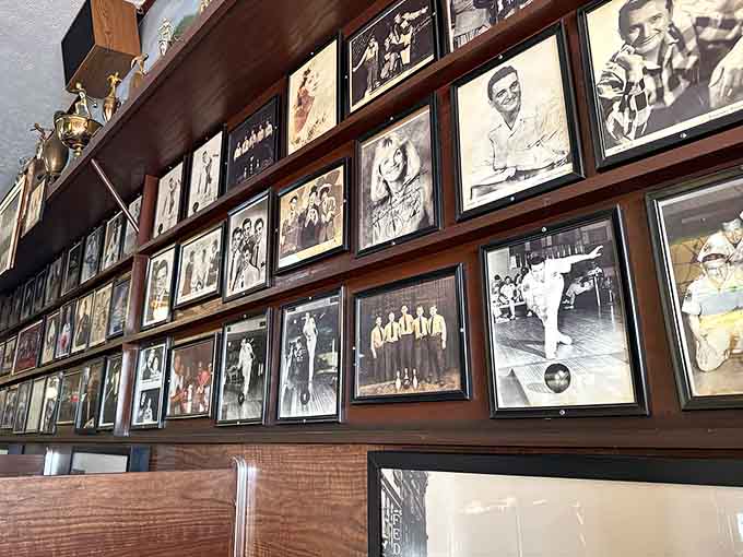 The wall of fame tells Akron's story through decades of photographs, sports teams, and smiling faces over pizza.