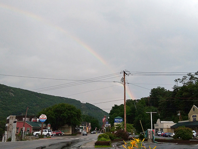 After summer rain, a rainbow arches over mountain slopes, nature's seal of approval on this perfectly preserved Vermont town.