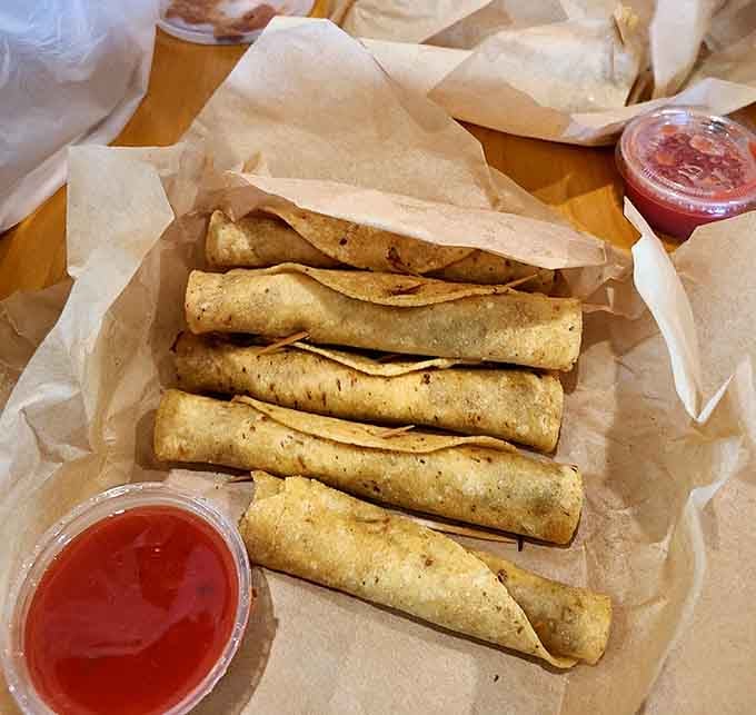 Golden rolled tacos lined up like delicious soldiers, crispy on the outside and packed with savory beef that makes dipping sauce optional but recommended.