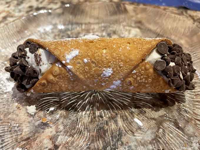 The cannoli arrives like a crispy, cream-filled trophy for making it through your mountain of pasta with style and determination.