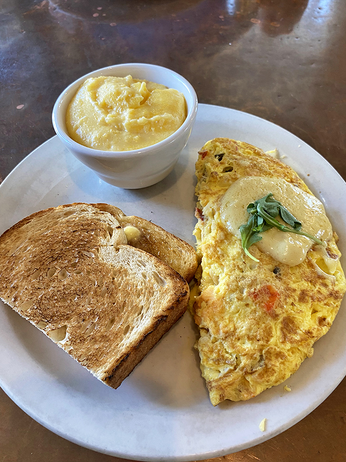 This isn't just an omelet &ndash; it's a fluffy egg envelope stuffed with a treasure trove of fillings and a side of golden grits.