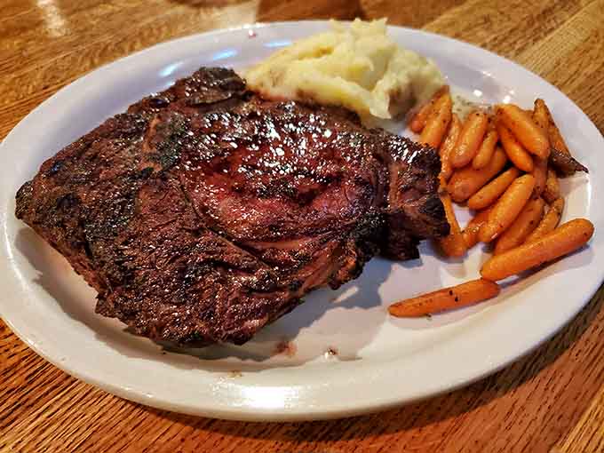 This massive ribeye showcases the beautiful marbling and expert preparation that keeps locals coming back for more delicious punishment.