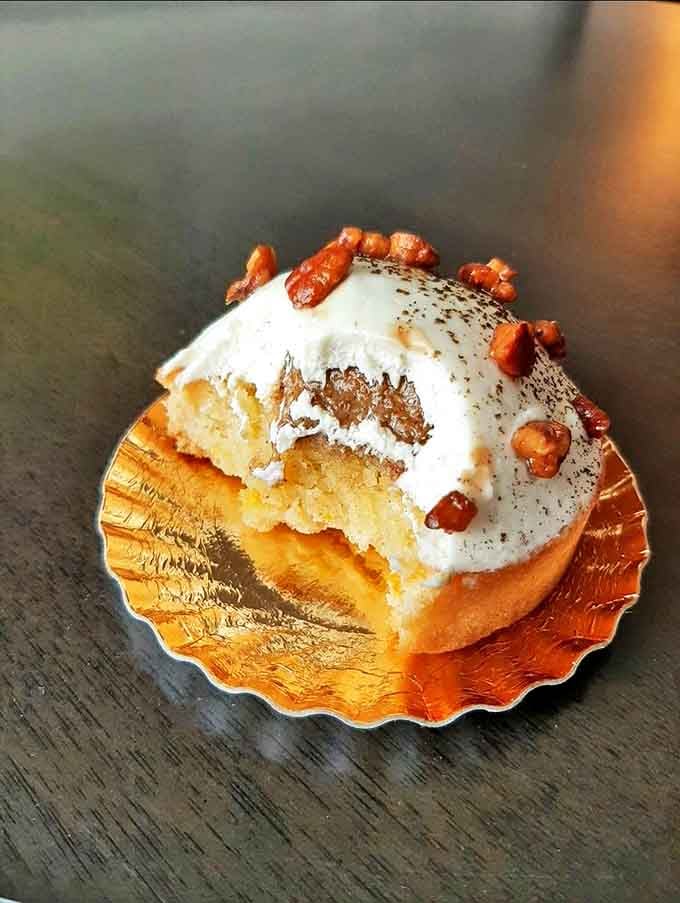 This apple tart transforms humble fruit into edible art, with precisely arranged slices nestled on buttery pastry and topped with nuts.