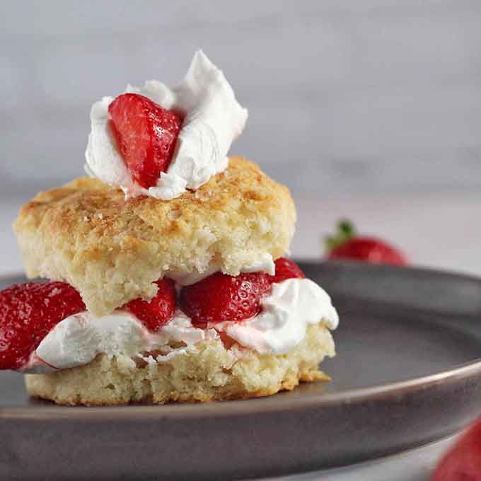 Strawberry shortcake stacked with fresh berries and cream, proving that dessert can be both elegant and utterly indulgent.