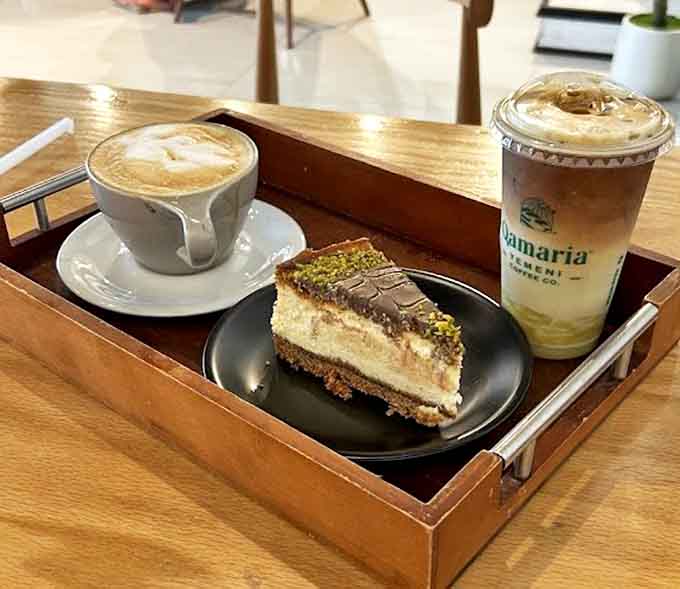 A perfect pairing: the velvety Pistachio Cheesecake alongside both hot and iced coffee presentations creates a dessert experience worth traveling for.