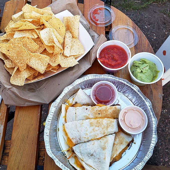 Crispy triangles surround a quesadilla like courtiers around royalty, with colorful dips standing by for their moment in the spotlight.