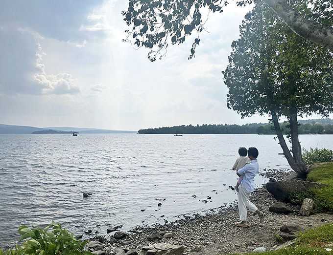 A perfect Maine moment: standing at water's edge with family, where Rangeley's lakes offer the ultimate screen-free entertainment.