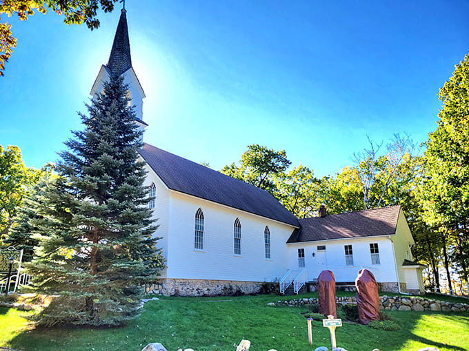 St. Ignatius Church stands sentinel among the trees, its white clapboard simplicity a testament to enduring faith and community.