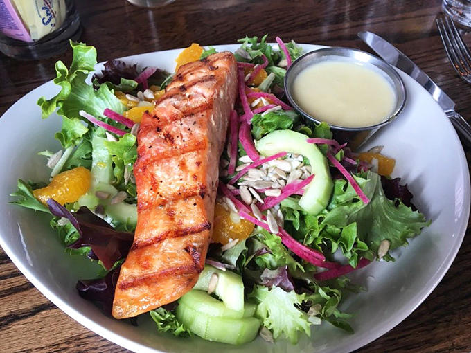 Grilled salmon atop fresh greens proves that not everything here requires loosening your belt, though it's still pretty satisfying.