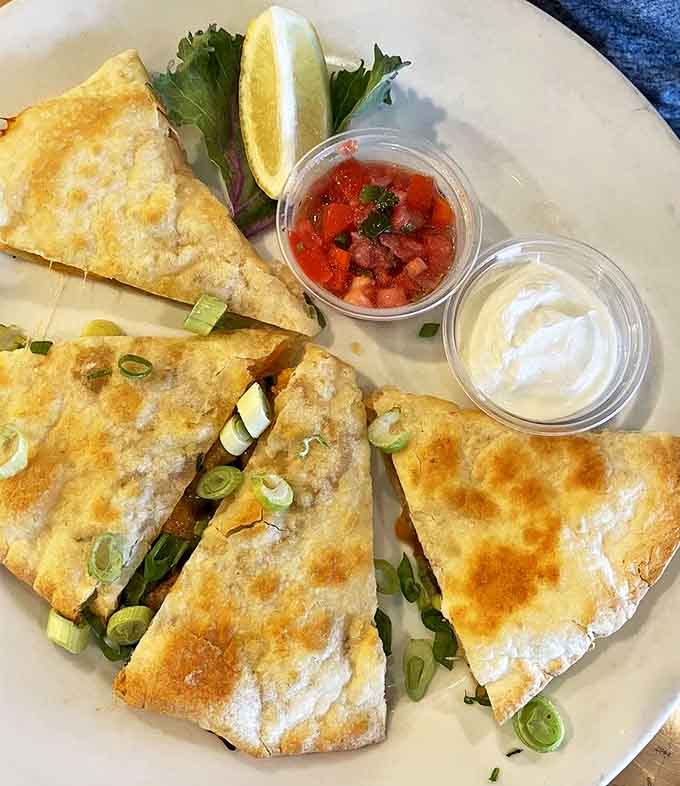 The shrimp quesadilla transforms a Mexican standard into Florida magic &ndash; each triangle revealing a treasure trove of flavors.