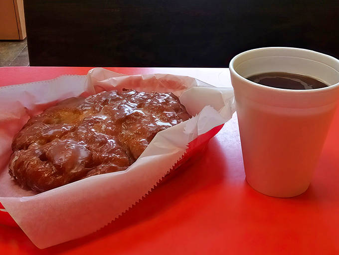 Simple pleasures: a warm fritter, a hot coffee, and a moment of sweet solitude before facing the day ahead.
