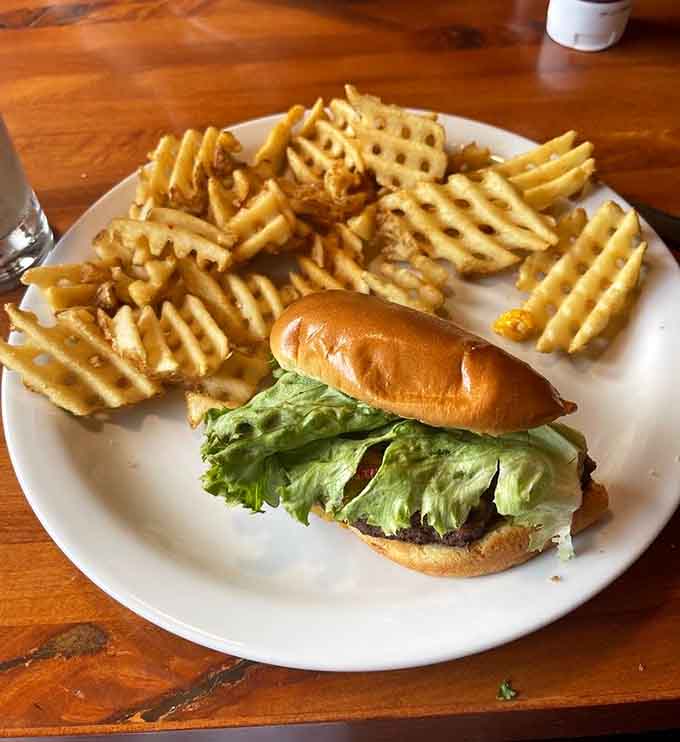 A classic bacon cheeseburger with waffle fries shows that sometimes simple done right beats complicated every time.