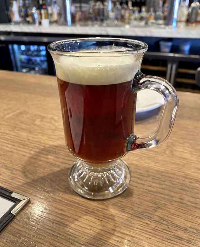 This Irish coffee, with its perfect layer of cream floating atop rich, dark brew, offers liquid comfort in a glass mug.