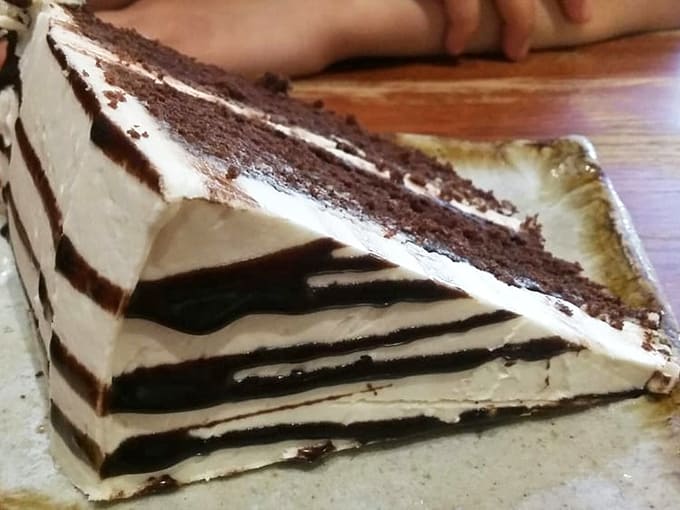 Layers of chocolate and cream stack up like the world's most delicious Jenga tower, daring you to keep a straight face while eating it.