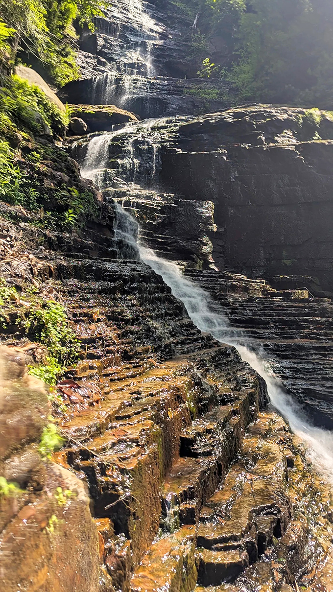 Water choreographs its descent over ancient stone steps, a performance millions of years in the making.