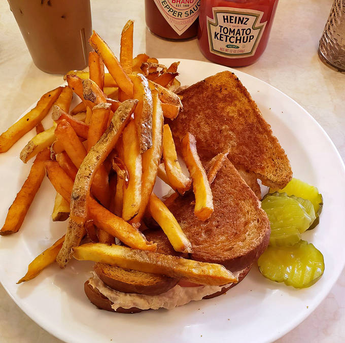 The humble tuna melt elevated to art form: golden-grilled bread, melty cheese, and a pile of fries that disappear one "just one more" at a time.