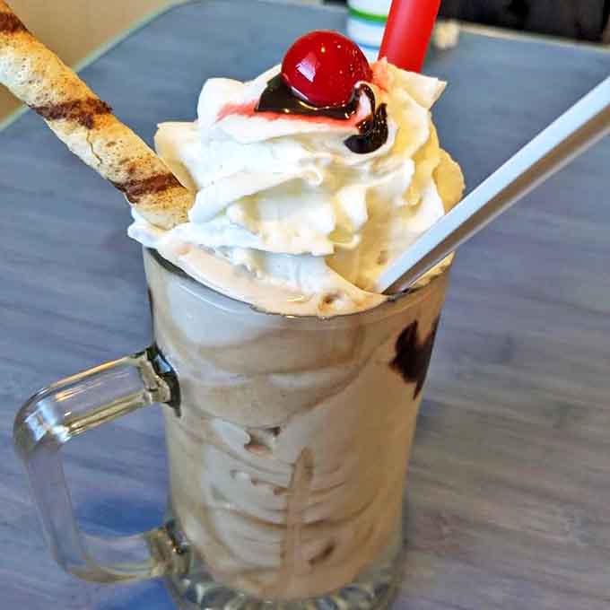 The vanilla milkshake arrives topped with whipped cream and a cherry, looking like it escaped from a 1950s soda fountain in the best way.