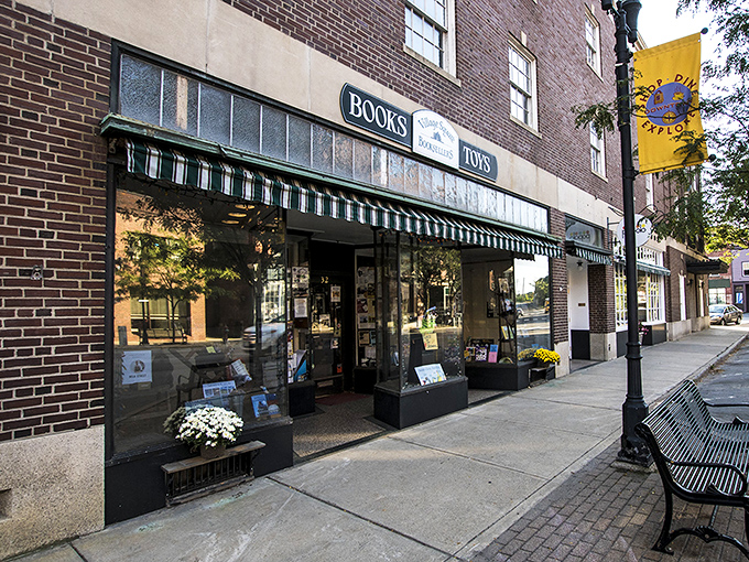 Village Square Booksellers invites bibliophiles to browse beneath classic awnings, a literary haven amid the historic brick buildings.