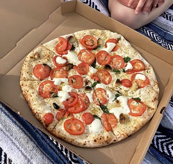 This white pizza showcases the farm's commitment to letting quality ingredients shine, with a drizzle of olive oil bringing everything together.