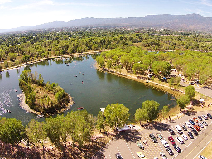 An aerial perspective reveals the park's lagoons embraced by greenery, a verdant island amid the surrounding desert landscape.