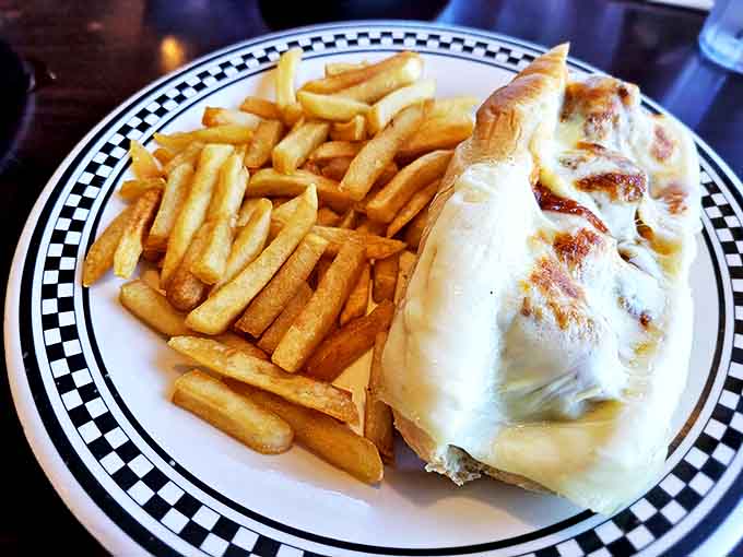 This isn't just a sandwich &ndash; it's architecture you can eat, with melted cheese cascading over the sides and fries that demand to be savored one by one.