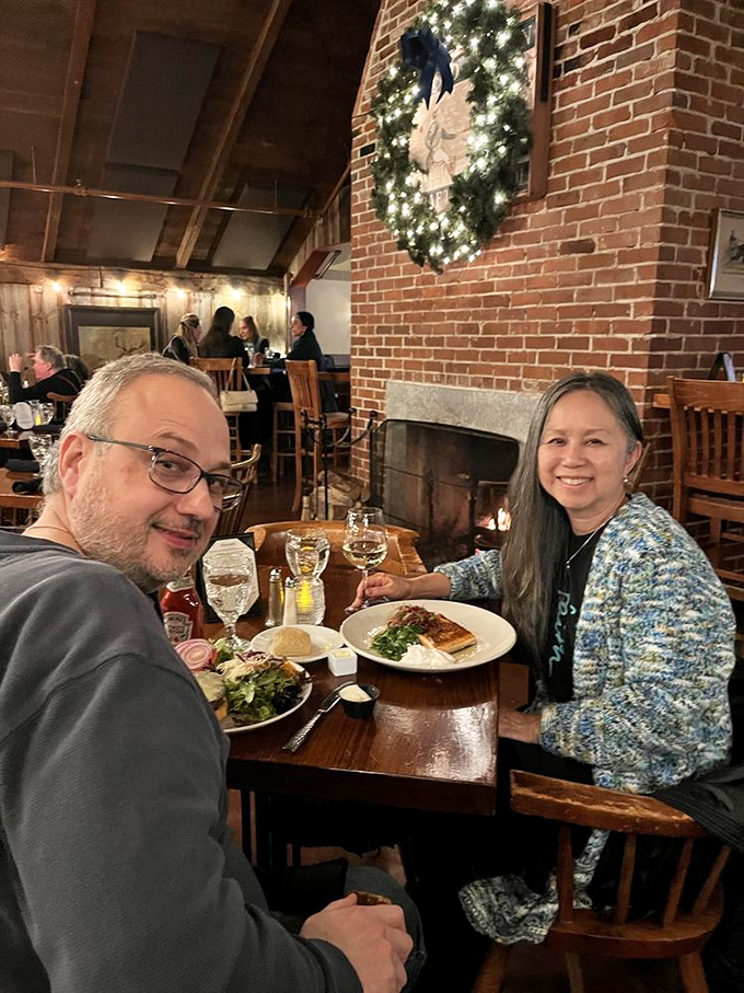 The crackling fireplace creates the perfect backdrop for an intimate dinner, where rustic charm meets culinary excellence in Vermont's most atmospheric dining room.