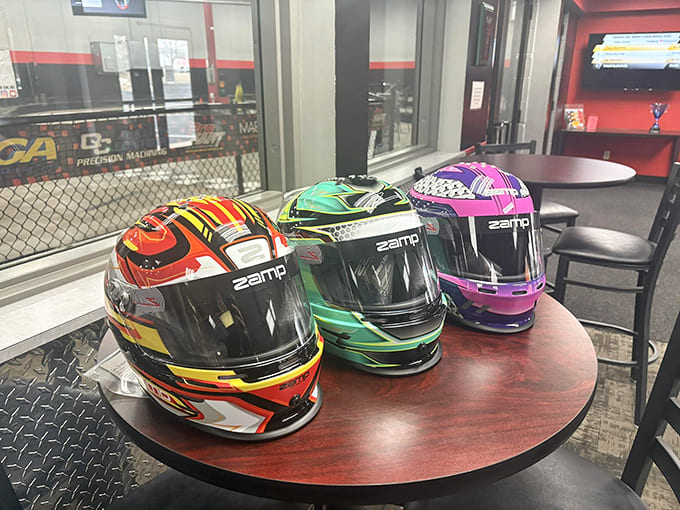 A colorful array of racing helmets awaits their next drivers. Each one holds the promise of speed and glory!